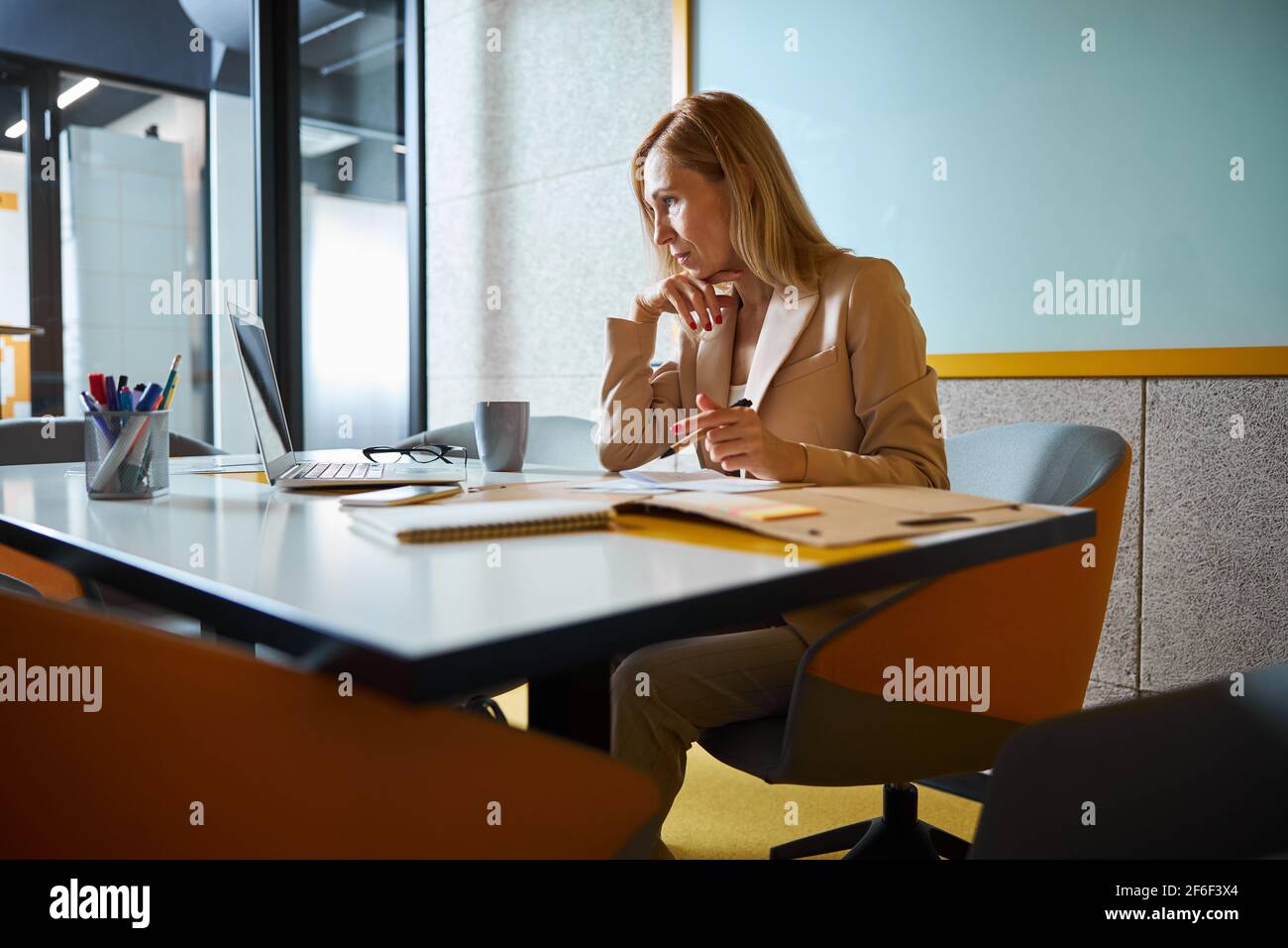Concentrated female person staring at screen of her laptop Stock Photo ...