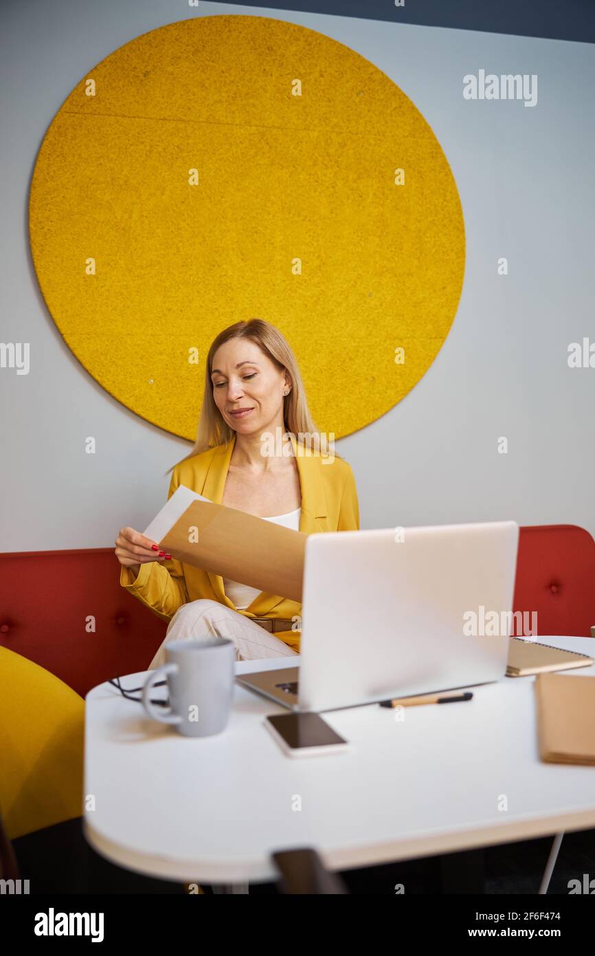 Attentive female person opening envelope and taking documents Stock ...