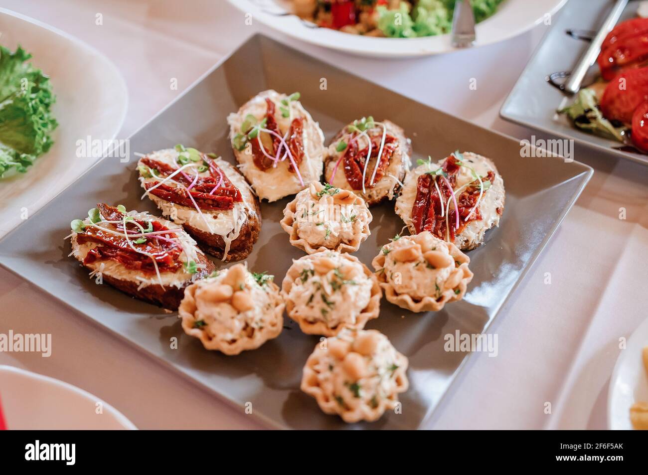 Canapes with sun-dried tomatoes and microgreen Stock Photo - Alamy