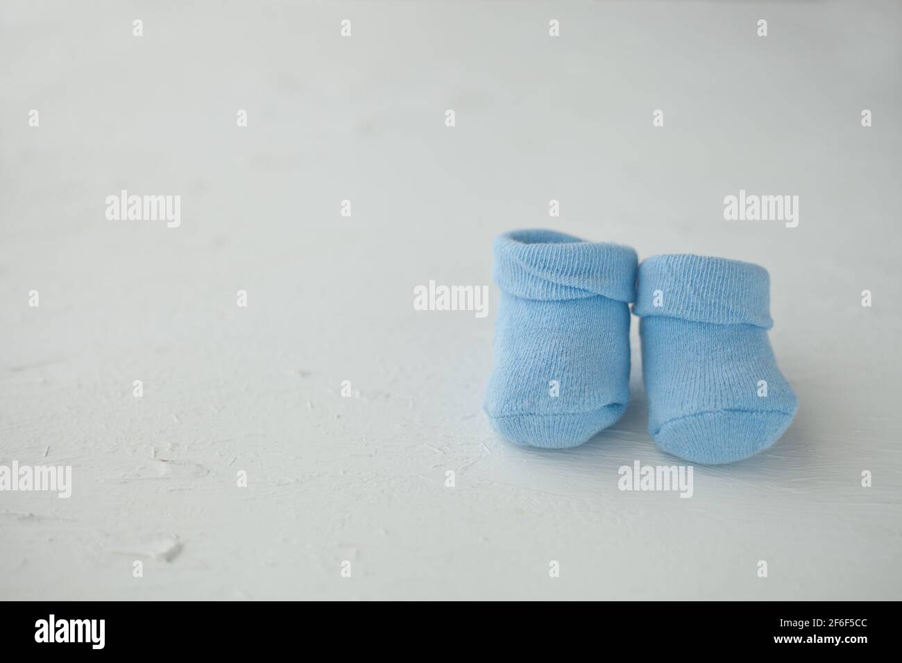 Blue baby socks on a textured rustic background with copy space ...