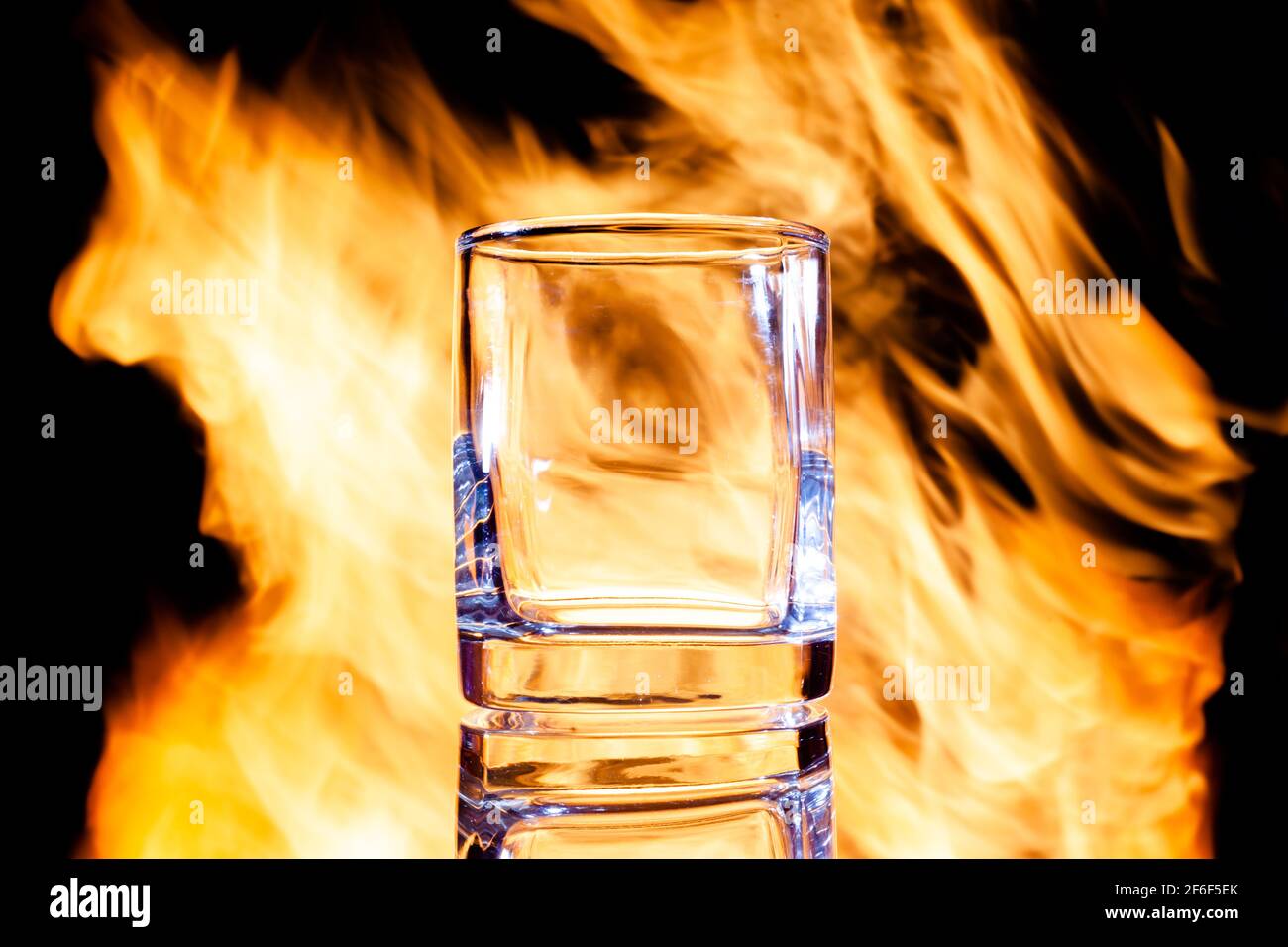 glass for alcohol in the background of fire Stock Photo - Alamy