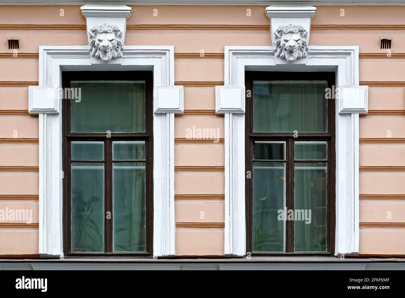 Two rectangular windows with a bas-relief on the background of a pink ...