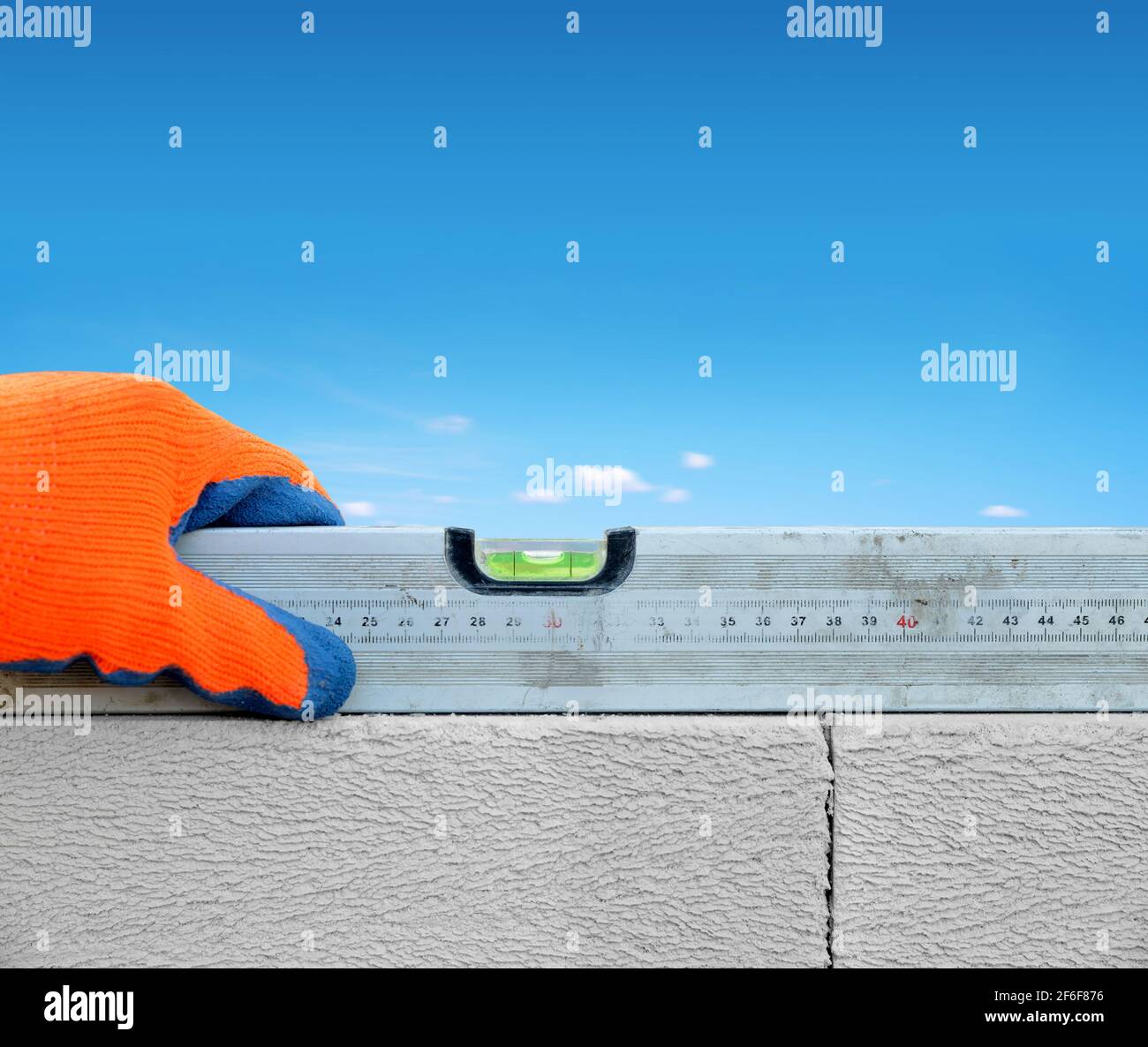 The bricklayer measures the wall with a spirit level Stock Photo - Alamy