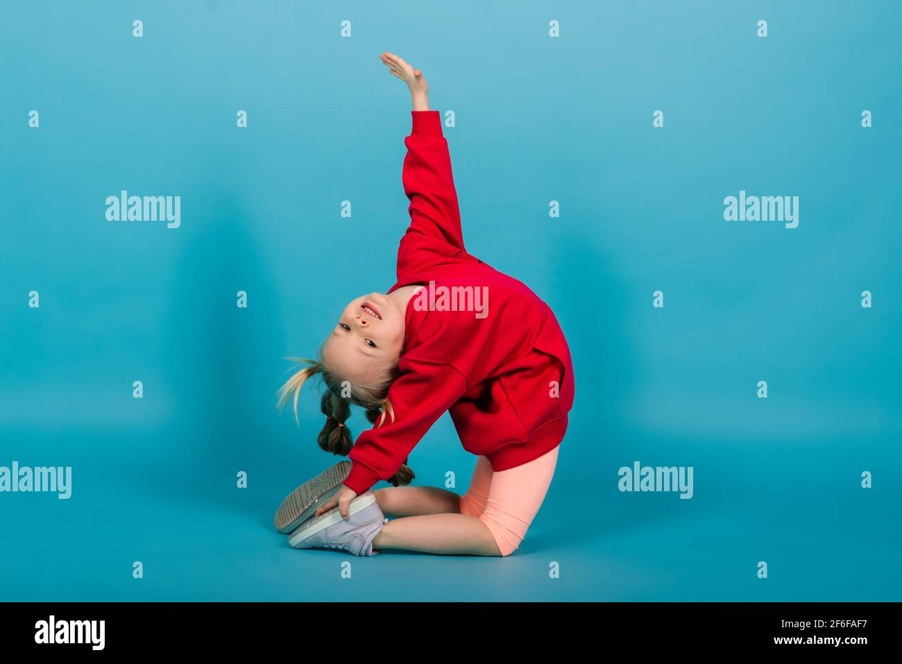Child girl doing fitness exercises, split, studio shot Stock Photo - Alamy