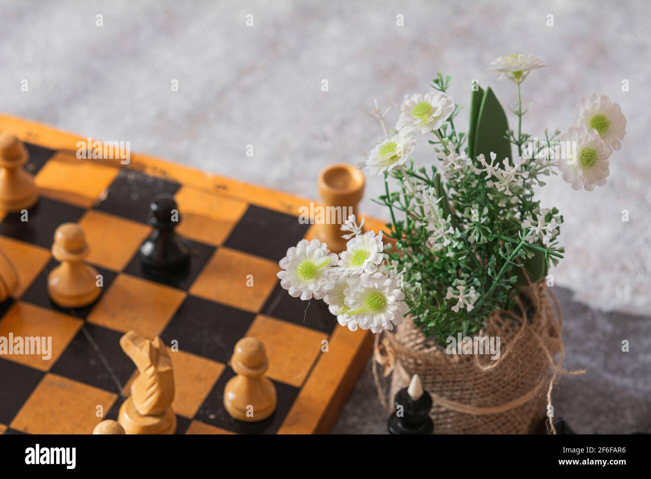 Chess. Chess board, chess pieces and flowers on a gray-blue background ...