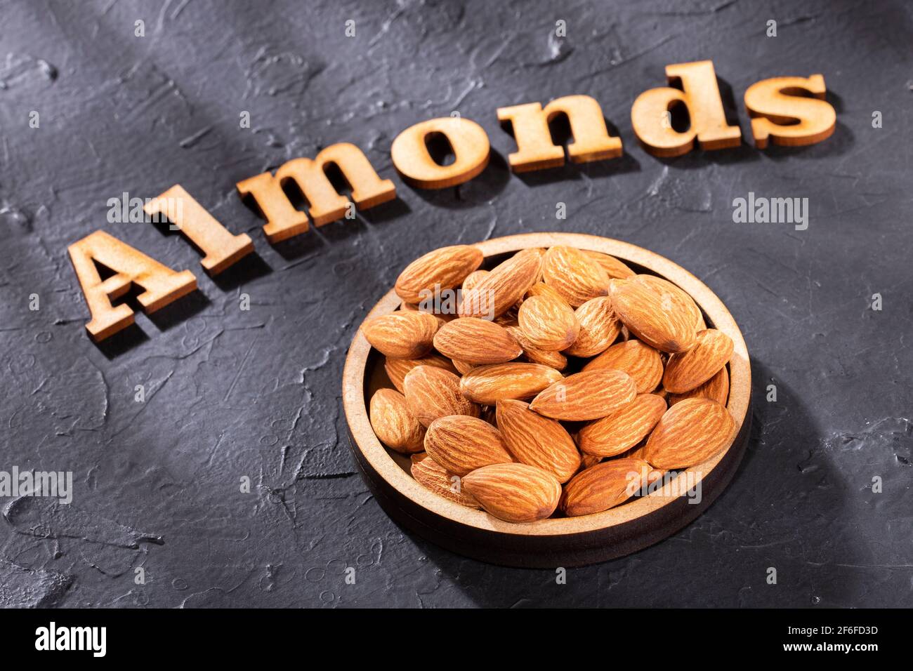 Prunus dulcis - Peeled almonds. Almonds word in wooden letters Stock ...