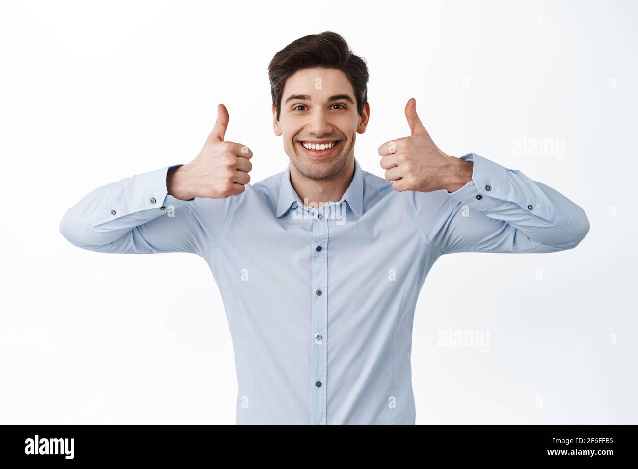 Super good. Smiling handsome man showing thumbs up in approval, like ...