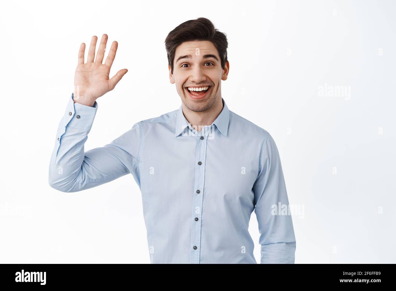 Friendly office worker waving hand and saying hello, smiling say hi ...