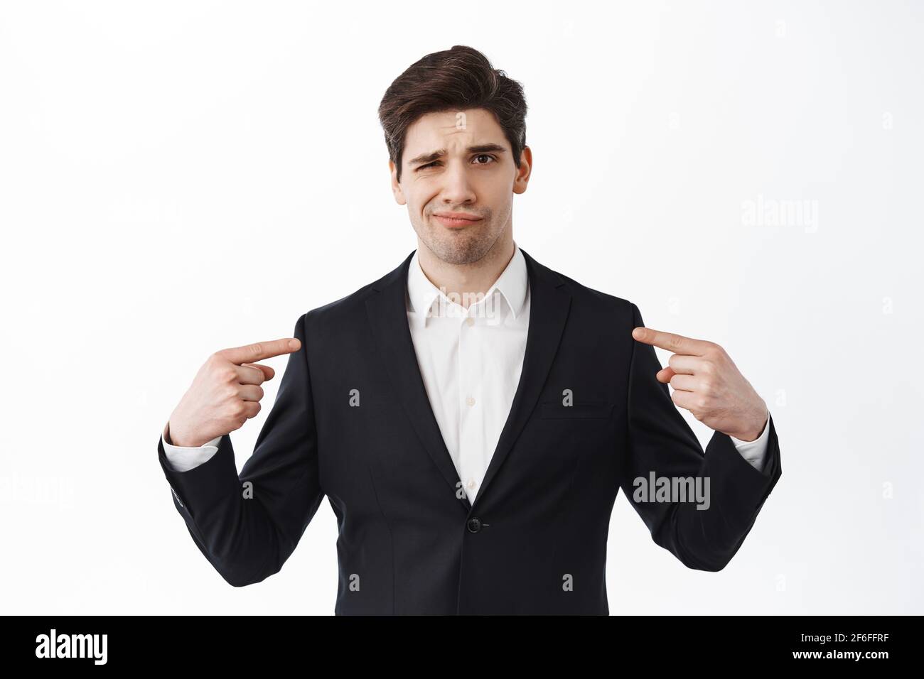 Unconfident and skeptical man in black formal suit points at himself ...