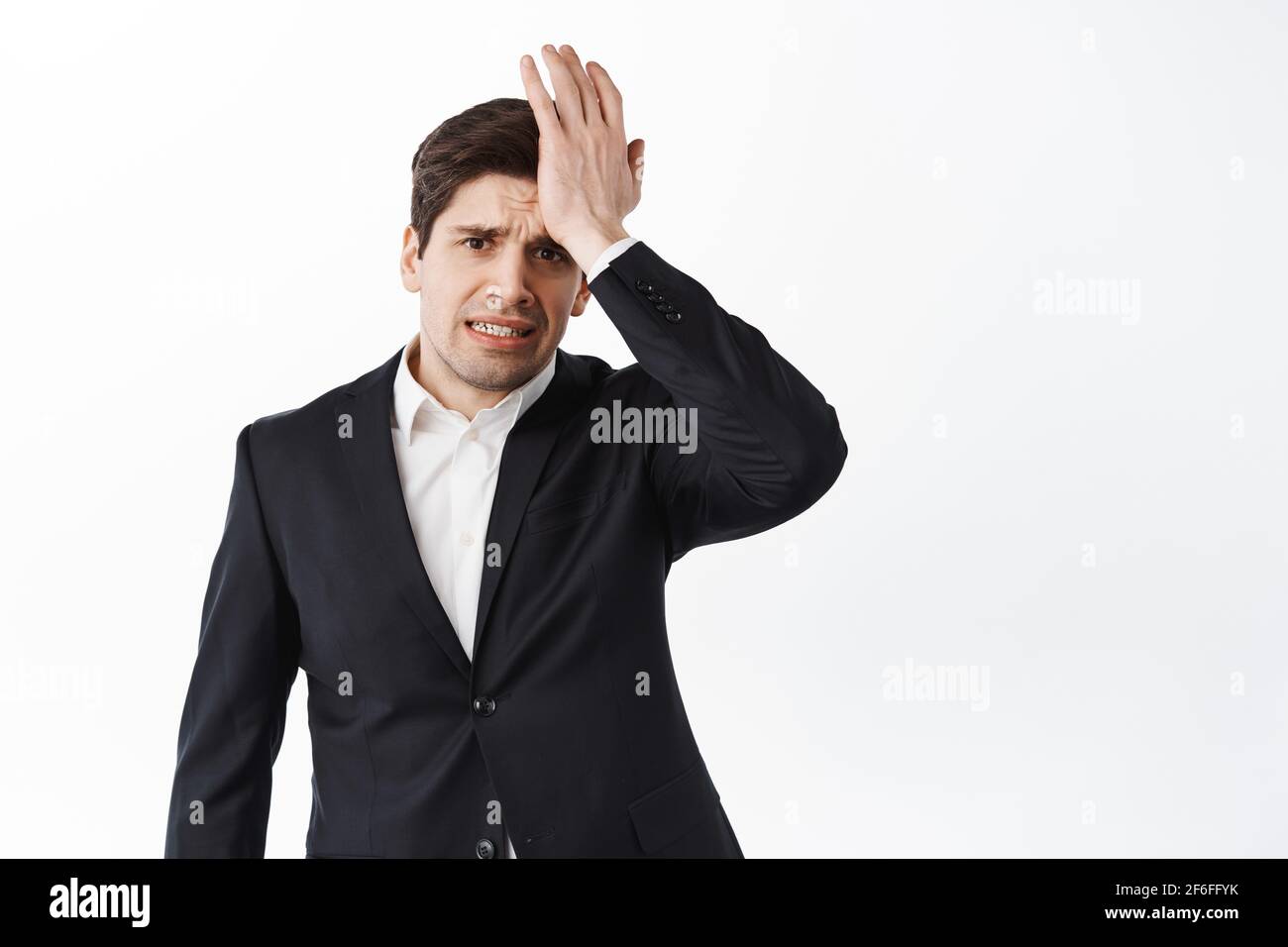 Worried and troubled corporate man hold hand on forehead and frowning ...