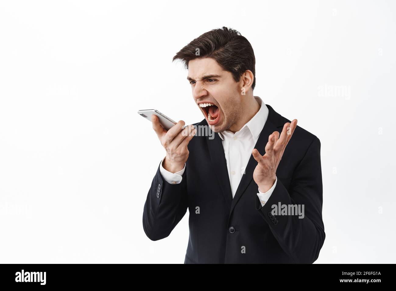 Angry businessman, entrepreneur scream at mobile phone, shouting in ...
