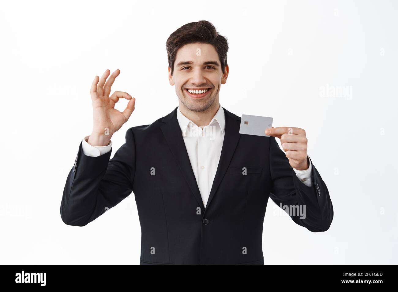 Good bank. Smiling business man shows okay sign and credit card ...