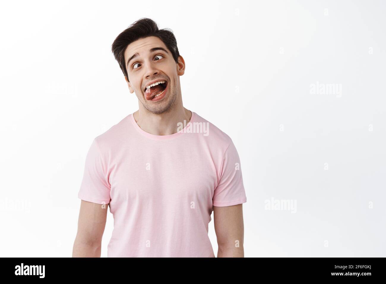 Funny man showing grimaces and tongue, making fun faces playfully, fool ...