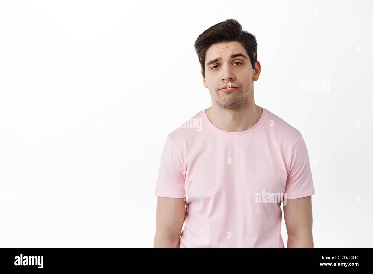 Indifferent and careless adult man staring at camera with unamused ...