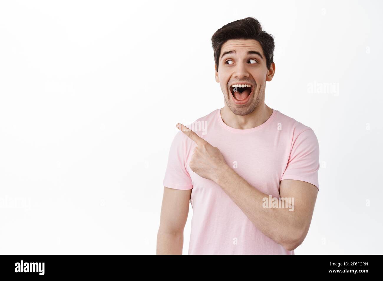 Happy funny man shouting from joy, pointing and looking at your logo ...