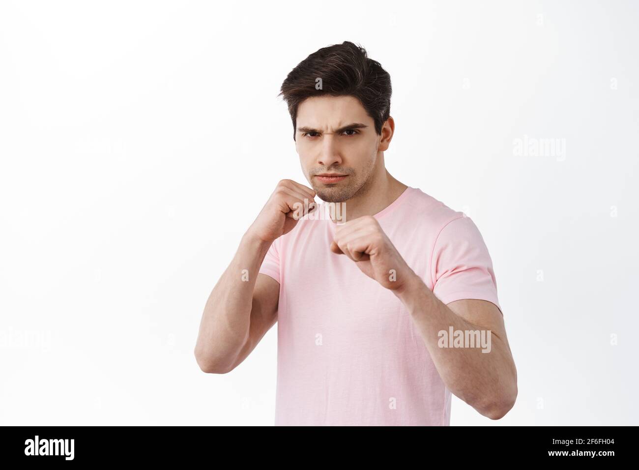 Serious determined man standing in boxing pose, fighting, ready to ...