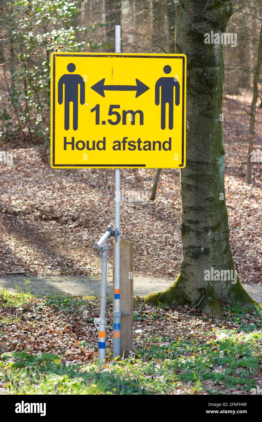 Yellow warning sign with the text in dutch: 1.5 meter, keep distance ...