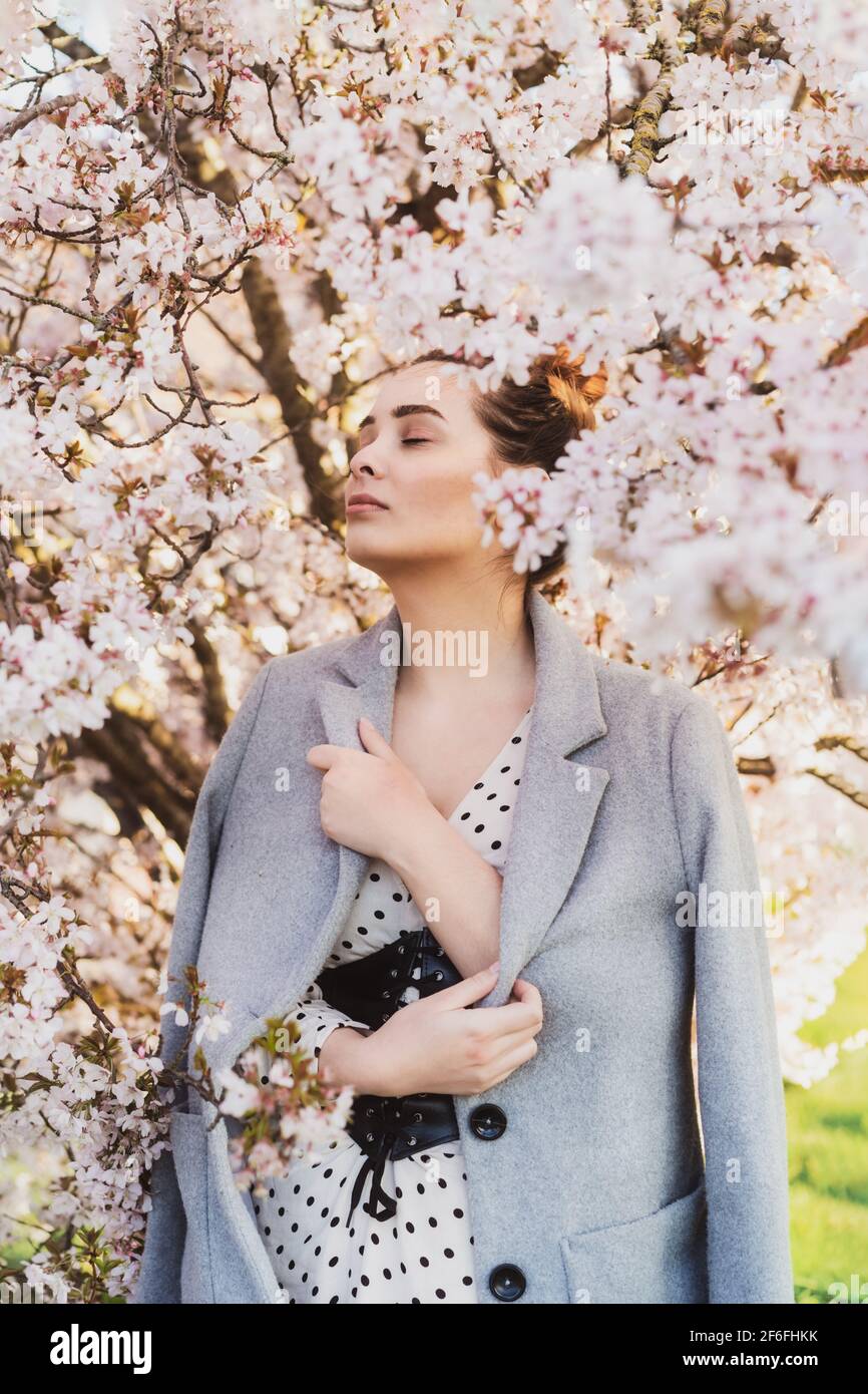 Spring Beautiful romantic woman with closed eyes standing in blooming ...