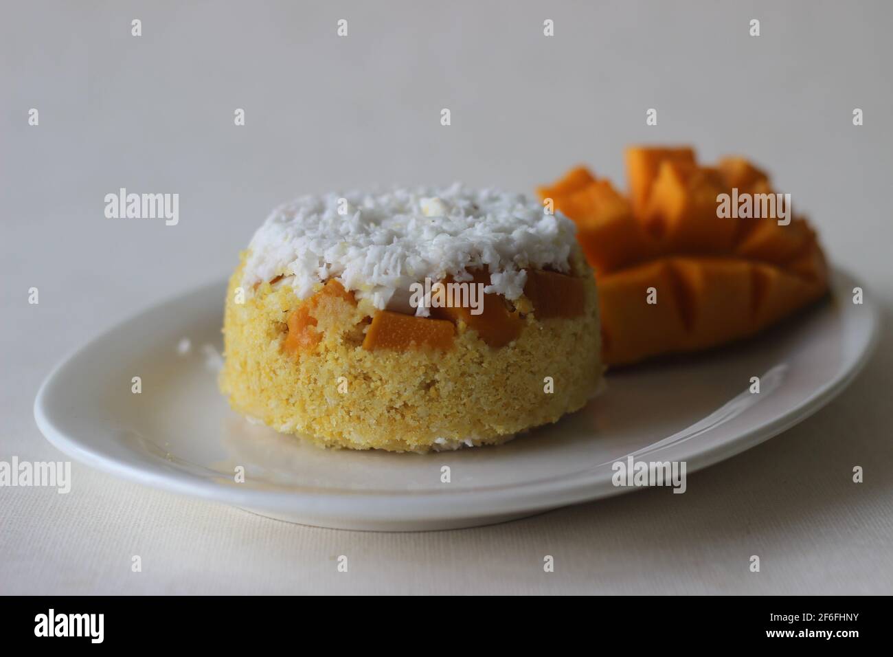 Steamed ground rice, layered with coconut shavings and mango. Locally ...