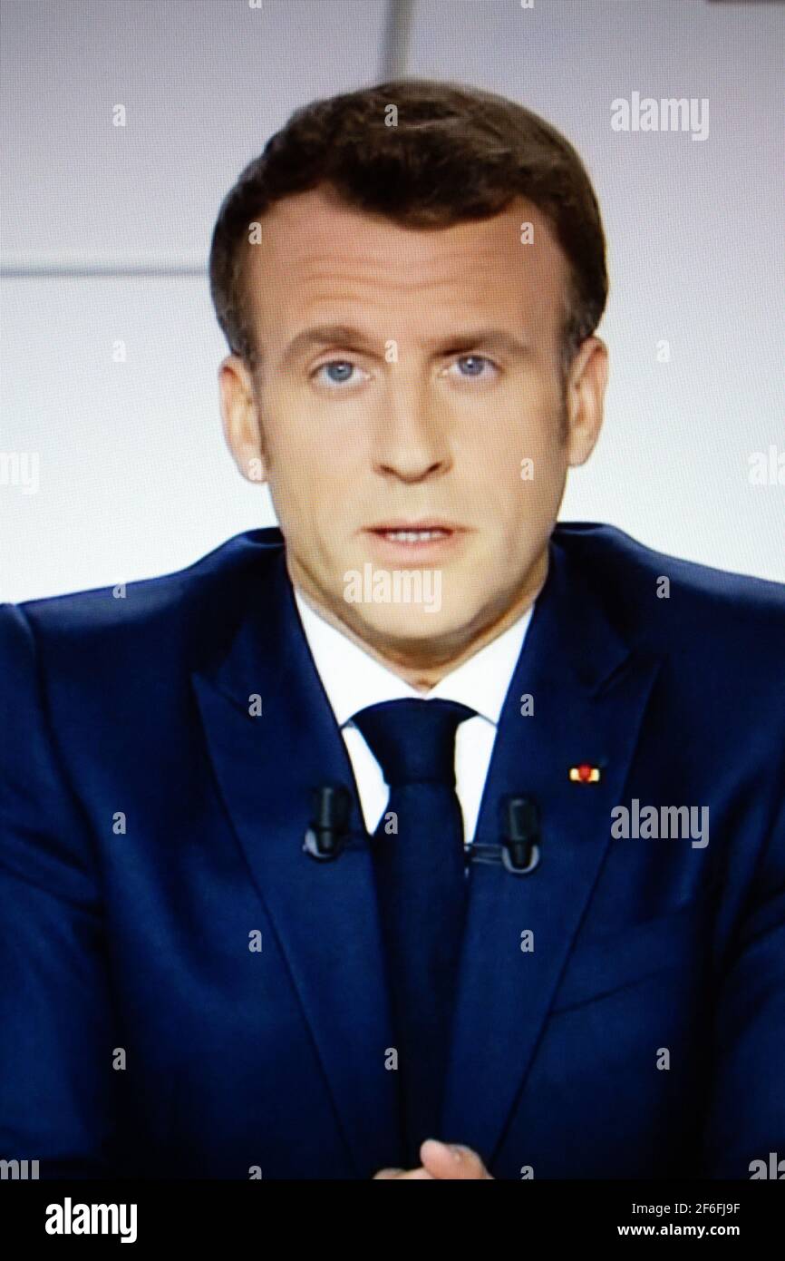 French President Emmanuel Macron is seen on a screen in Paris on March ...