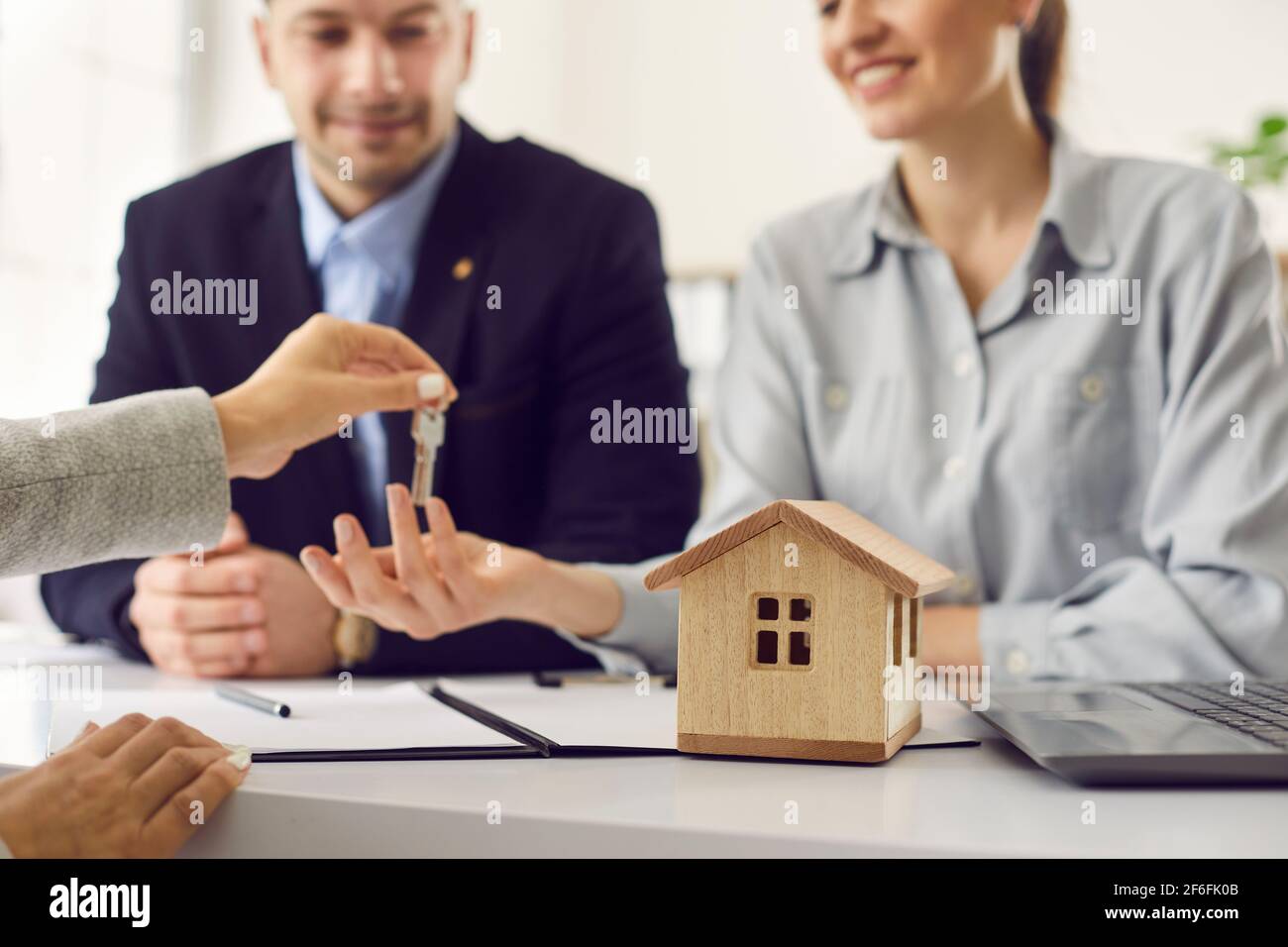 Happy couple taking key from new house apartment after signing mortgage ...