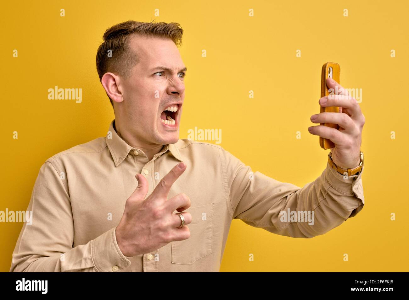 Young Angry Male Screaming At Mobile Phone Camera While Talking On ...