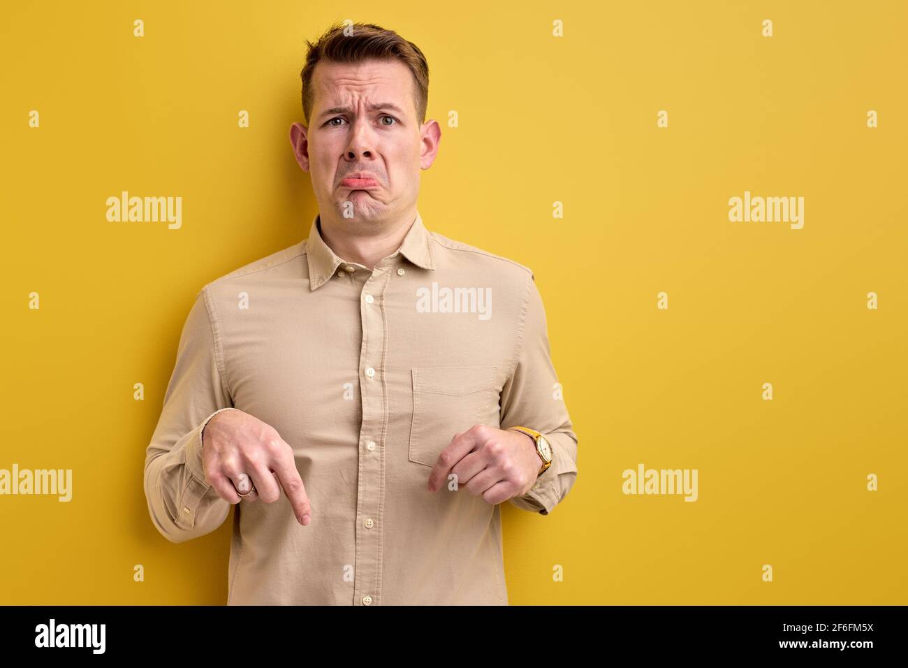 Crying infantile adult man ask to pay attention, pointing finger down ...