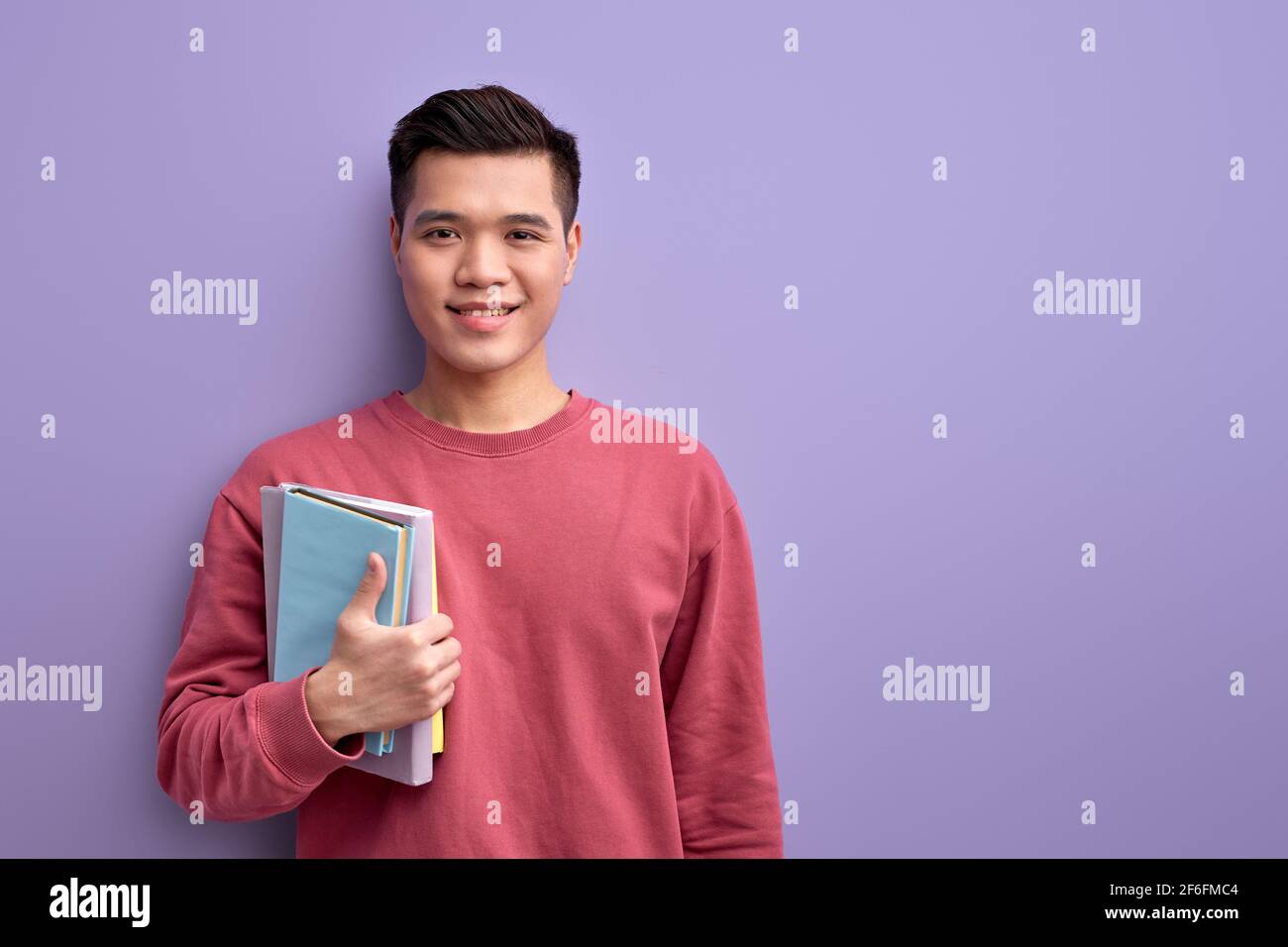 Smiling Asian guy with book in hands enjoy education and university ...