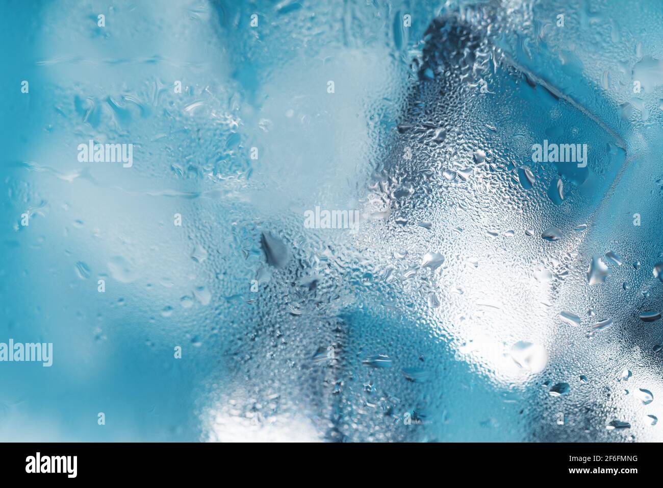 Ice cubes in a misted glass with drops of ice water close-up macro. Refreshing and chilling ...
