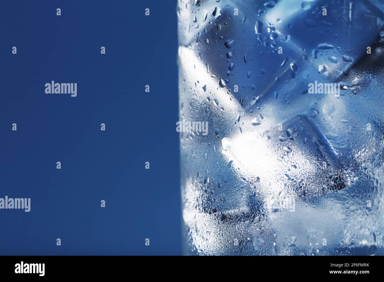 Ice cubes in a misted glass with drops of ice water close-up macro. Refreshing and chilling ...