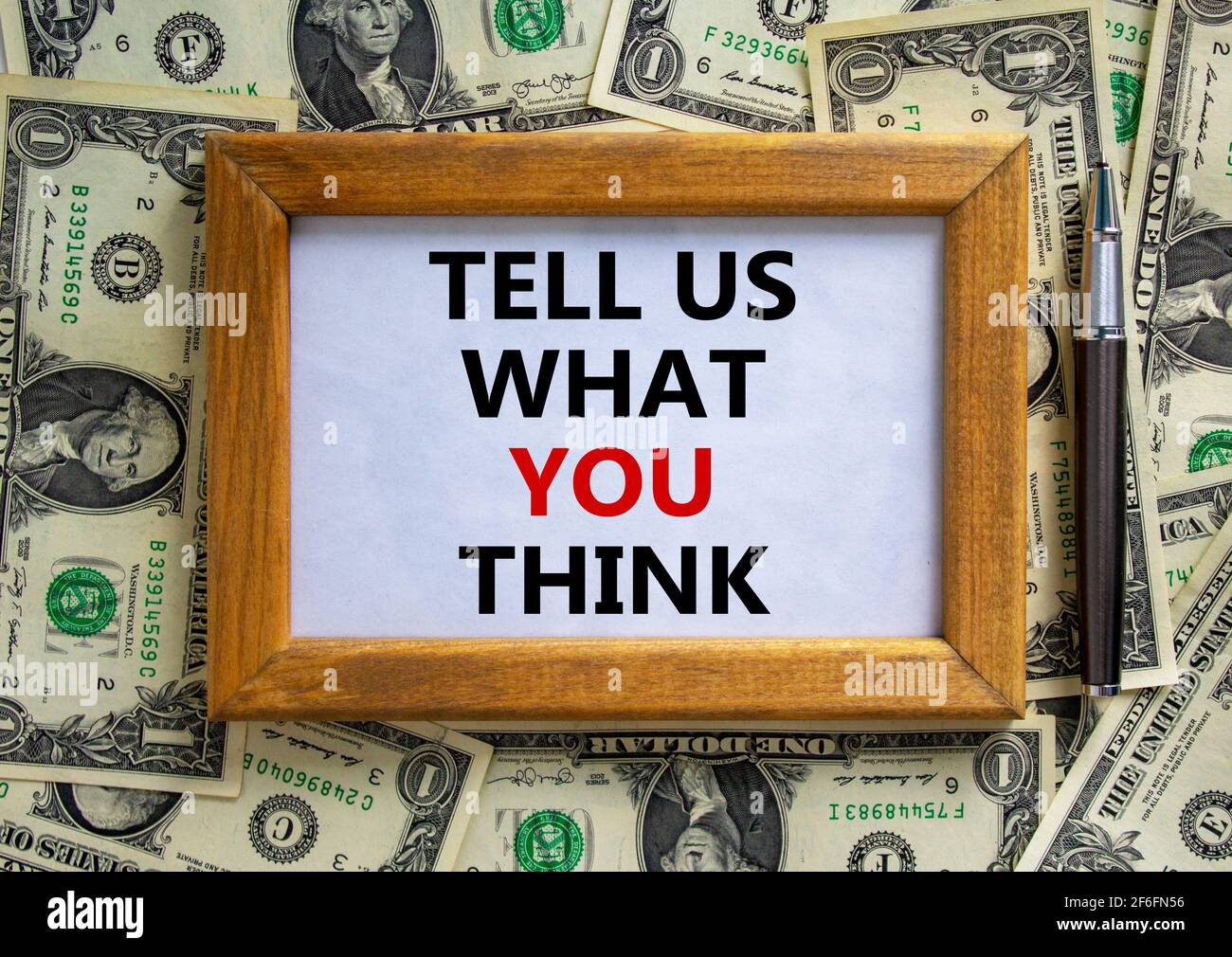 Support symbol. Wooden frame with words 'tell us what you think' on ...