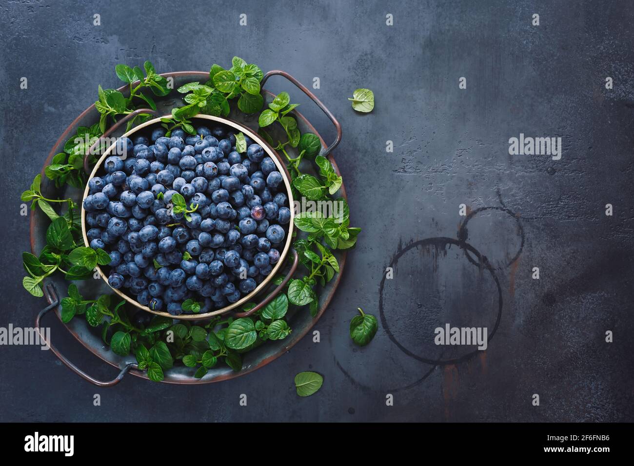 Plate of blueberries. Plate full of ripe blueberries placed on black ...