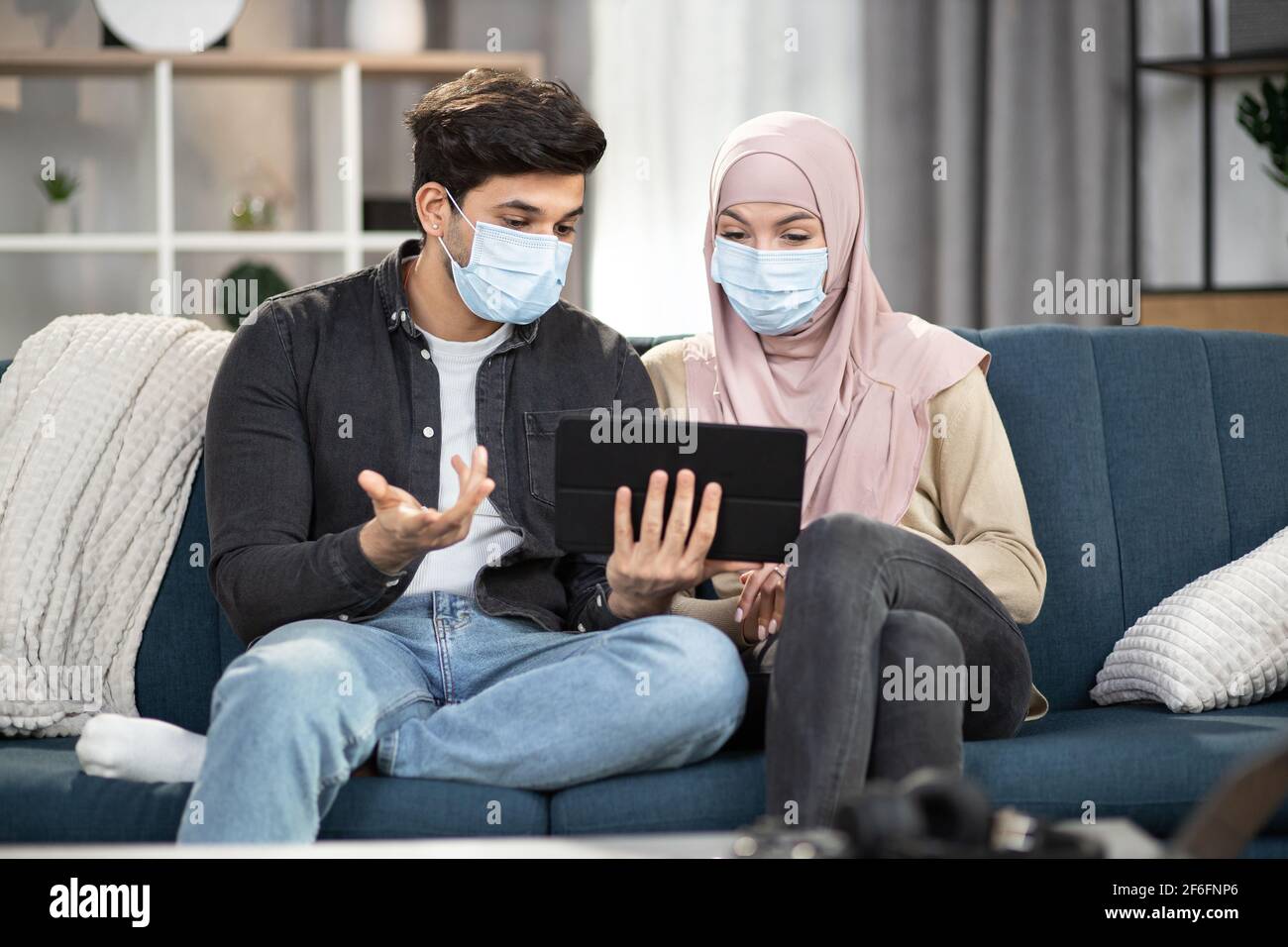 Handsome Arabian man in protective mask, talking and gesturing to his ...