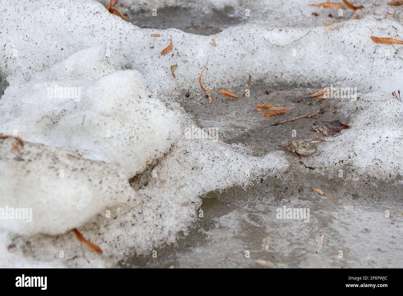 Early spring time dirty gray melted snow with sand pattern texture ...