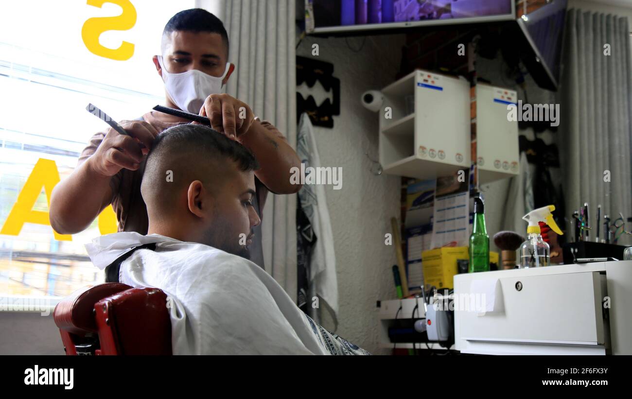 salvador, bahia, brazil - december 9, 2020: barber is seen working in a ...