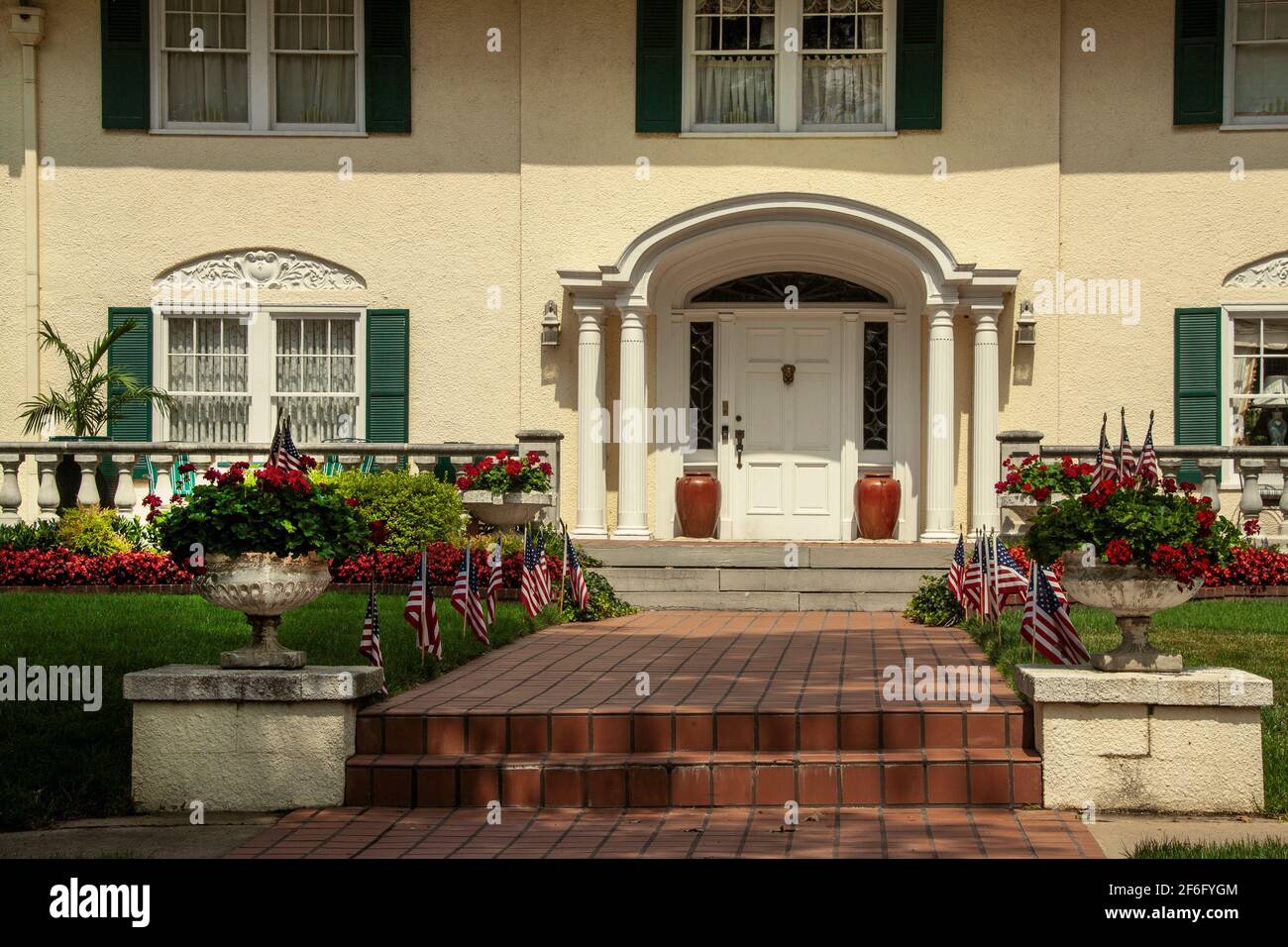 Classical upscale home entrance with pretty green shutters and pillars ...