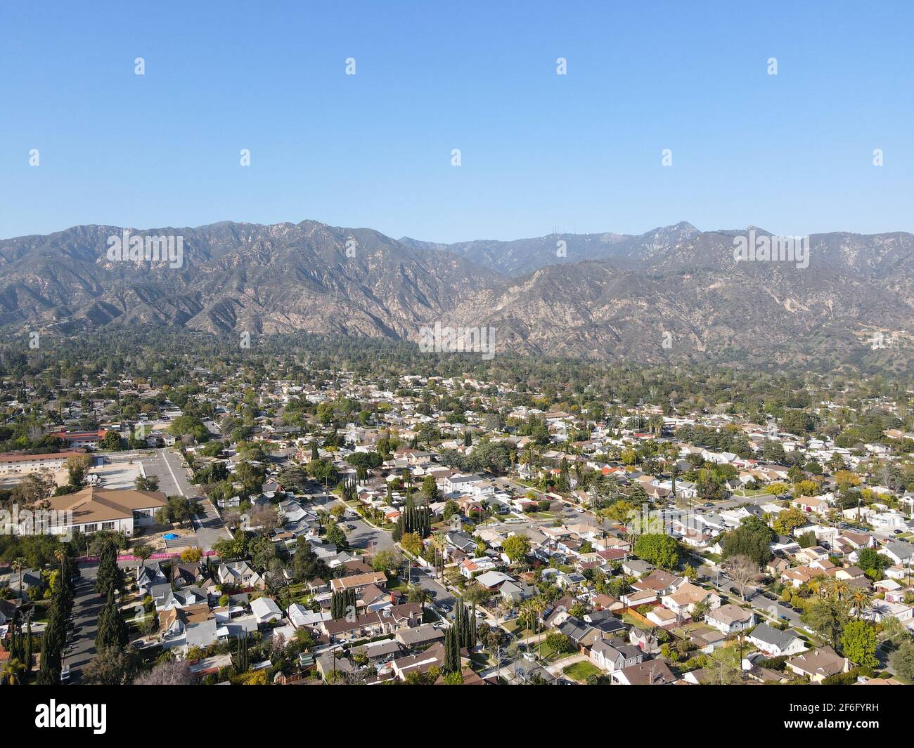 Aerial view above Pasadena neighborhood with mountain in the background ...