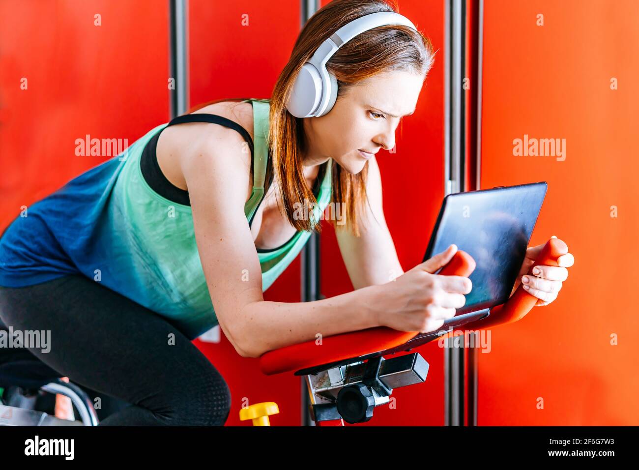 young beautiful woman doing sports with music headphones looking at the ...