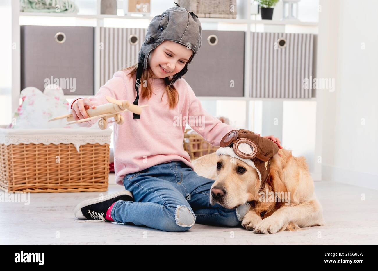 Little girl play in plane pilot with golden retriever dog Stock Photo ...