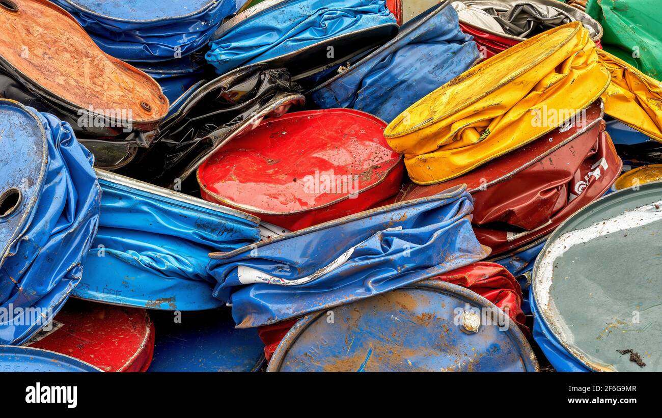 A pile of multicolored pressed metal barrels. Scrap metal for recycling ...