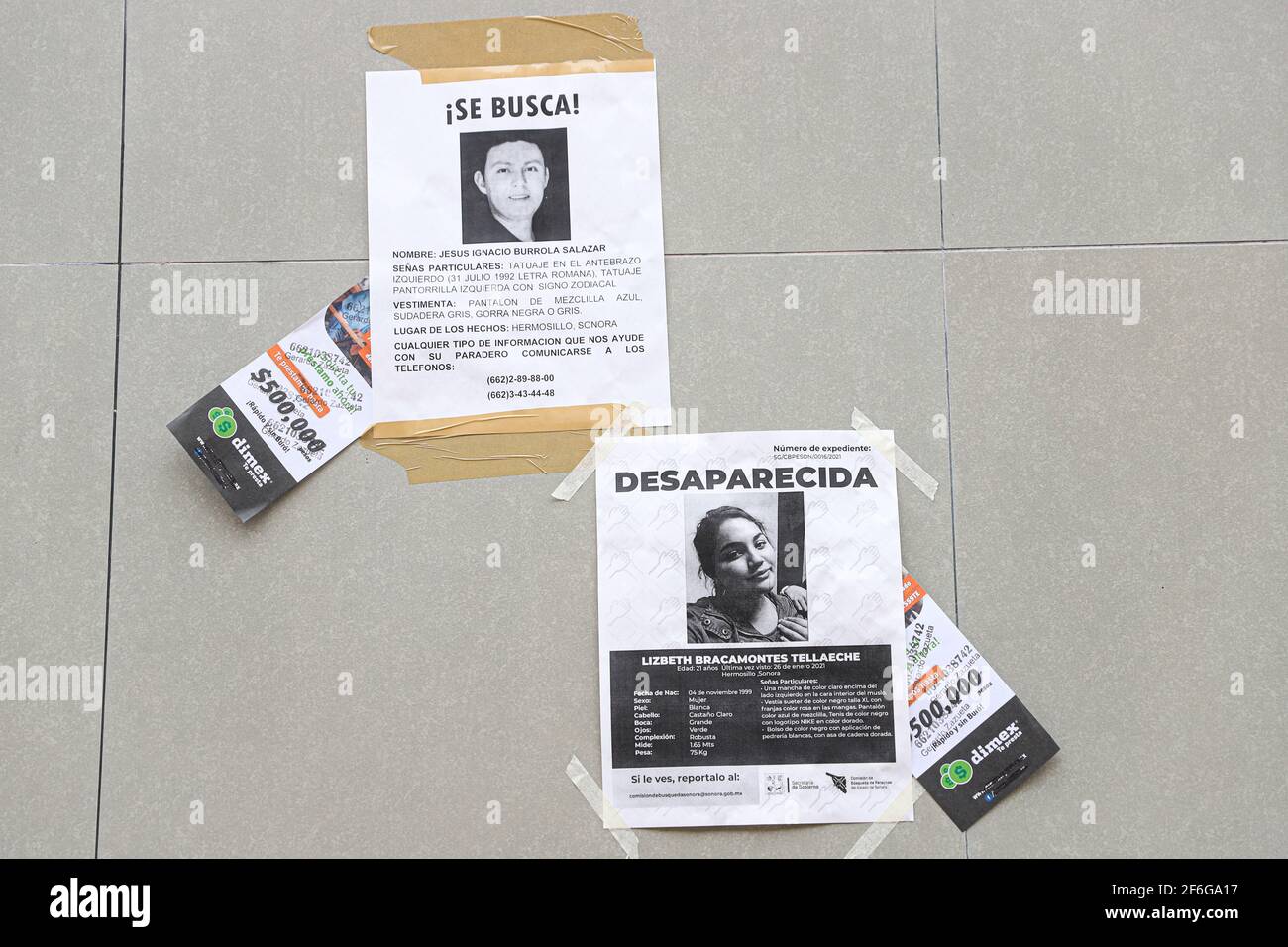 Posters with photographs of missing persons taped to a wall in downtown ...