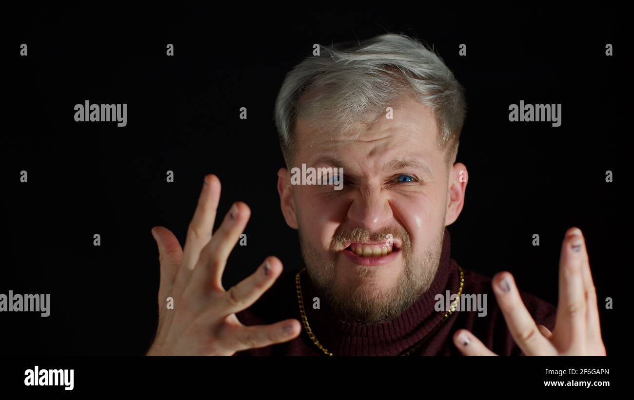 Portrait of angry annoyed young man screaming to the camera with raised ...