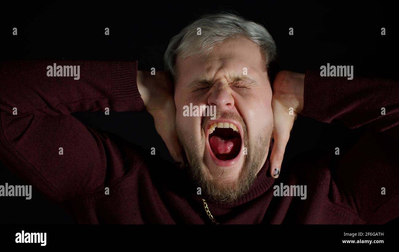 Frightened stylish man scared fearful, covering ears with hands ...