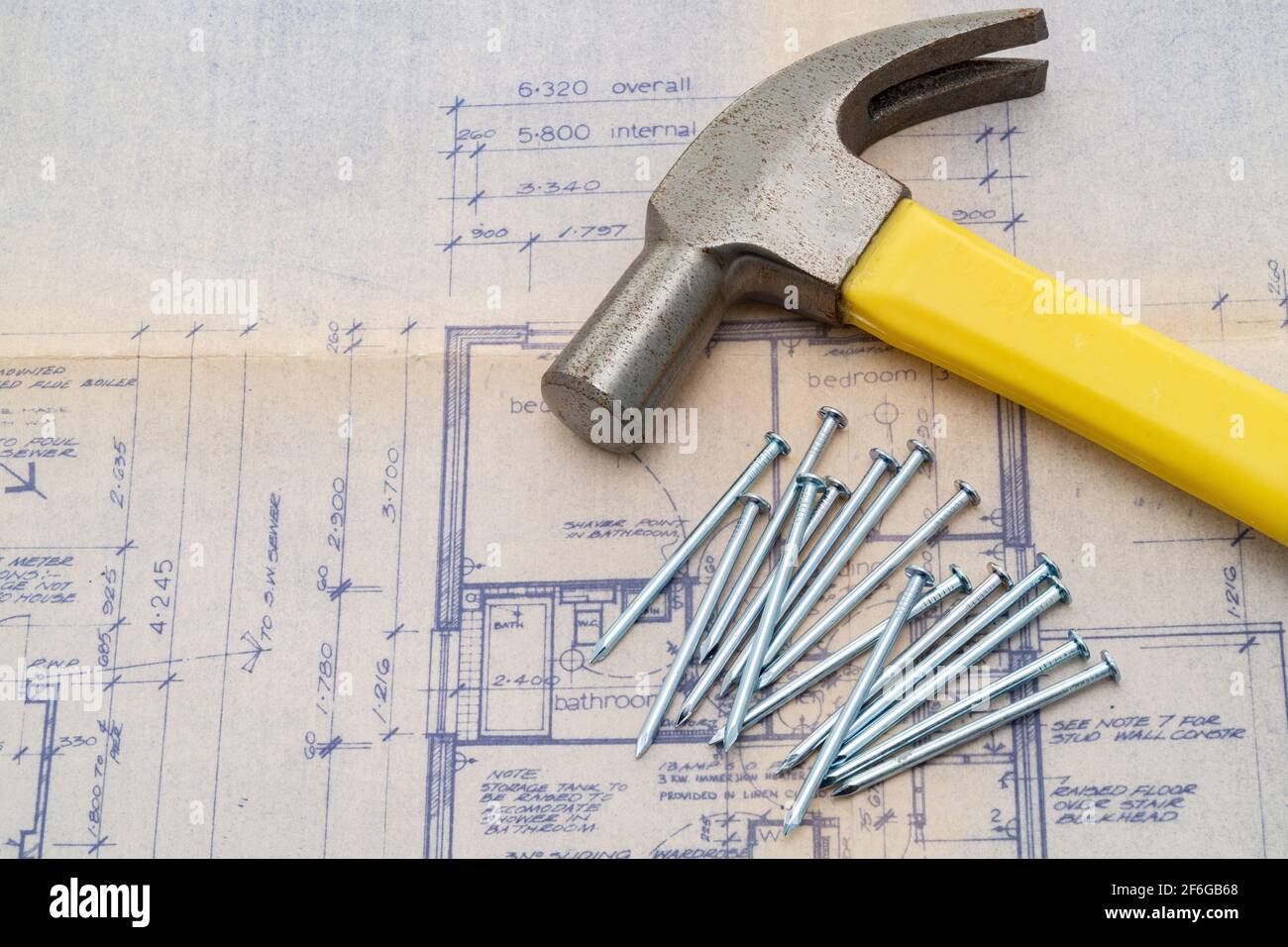 Hammer and nails placed on a house construction blueprint Stock Photo ...