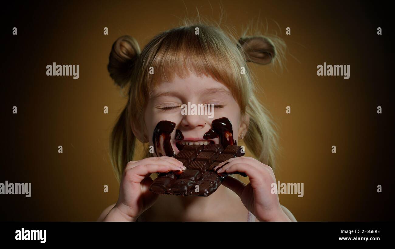 Portrait of teen smiling child kid girl smears face with melted ...