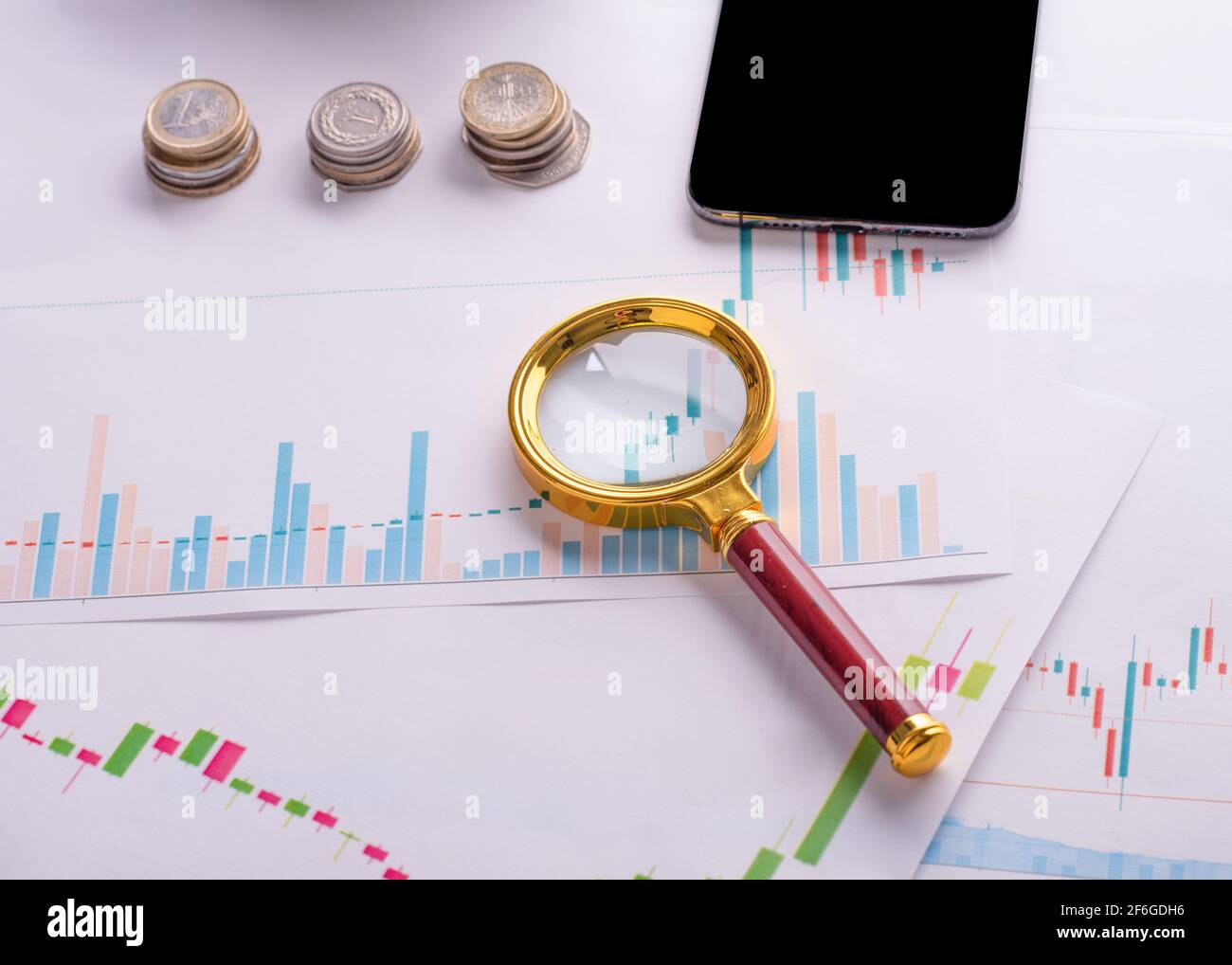 phone, coins, magnifying glass on chart Stock Photo - Alamy