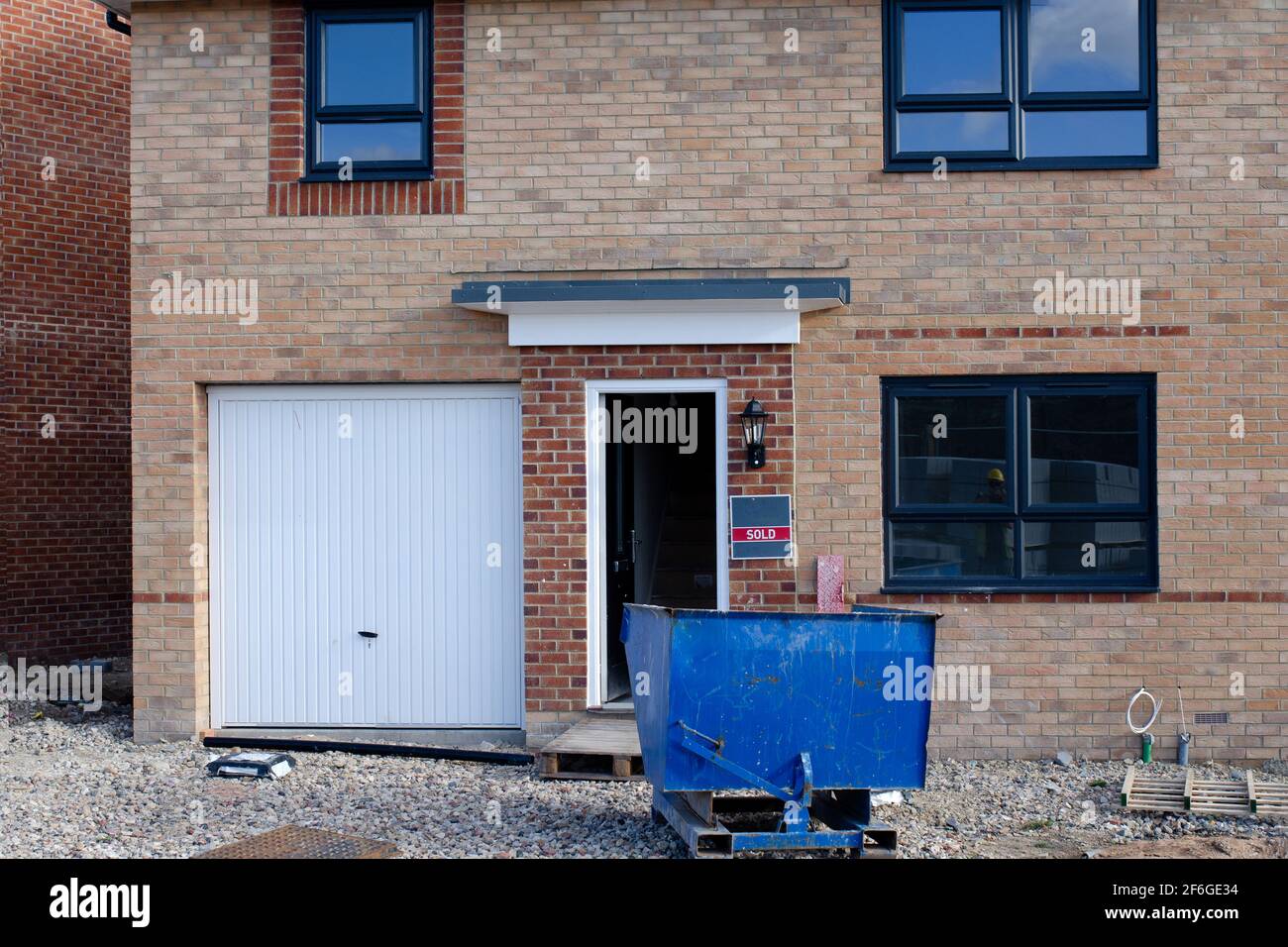 An ordinary new house for sale and blue recycling skip in front of it ...