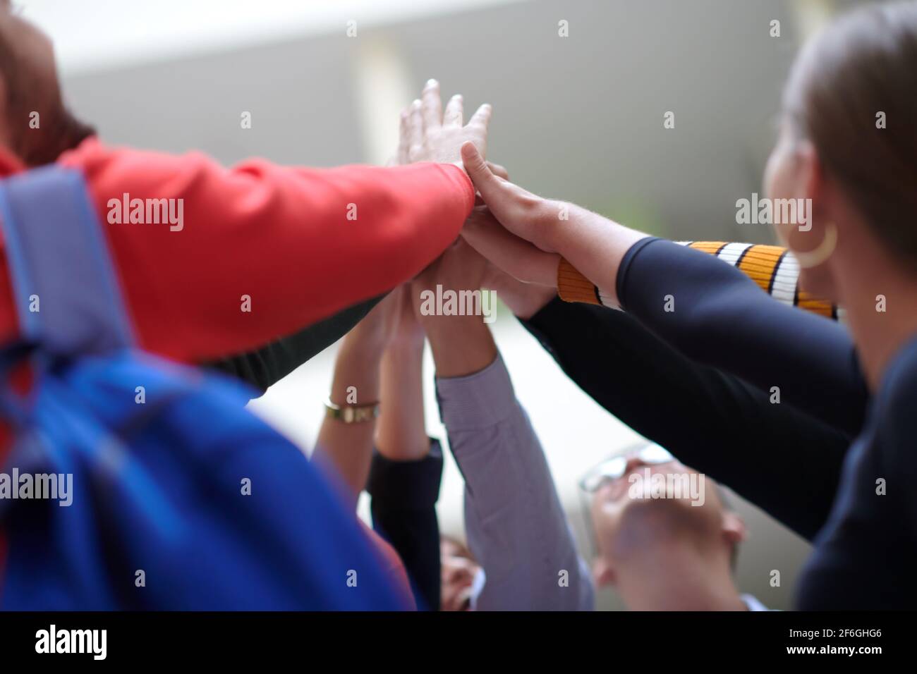 Happy Students Putting their Hands Together in the Air Inside the ...