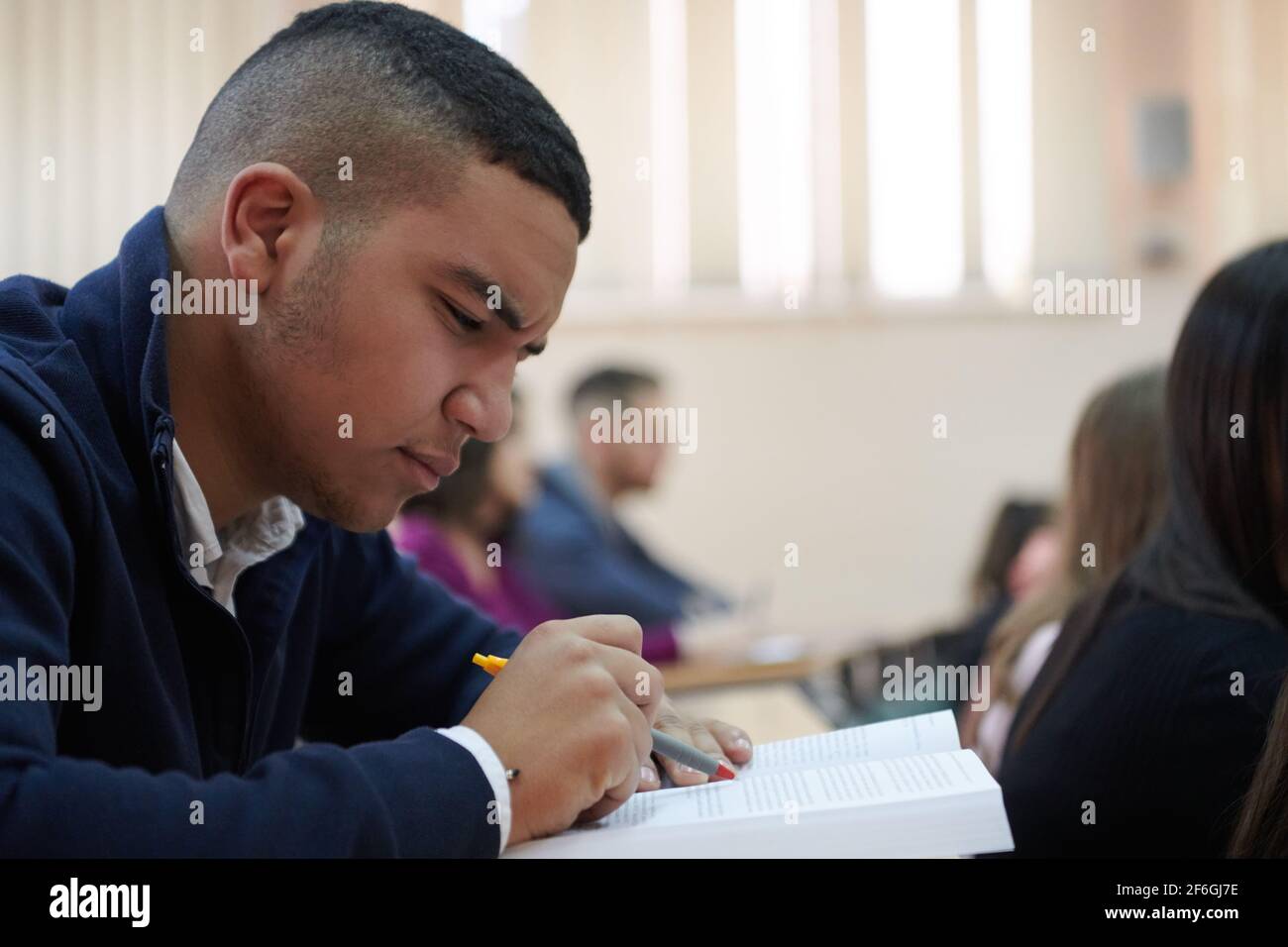 student taking notes while studying in high school. Satisfied young man ...