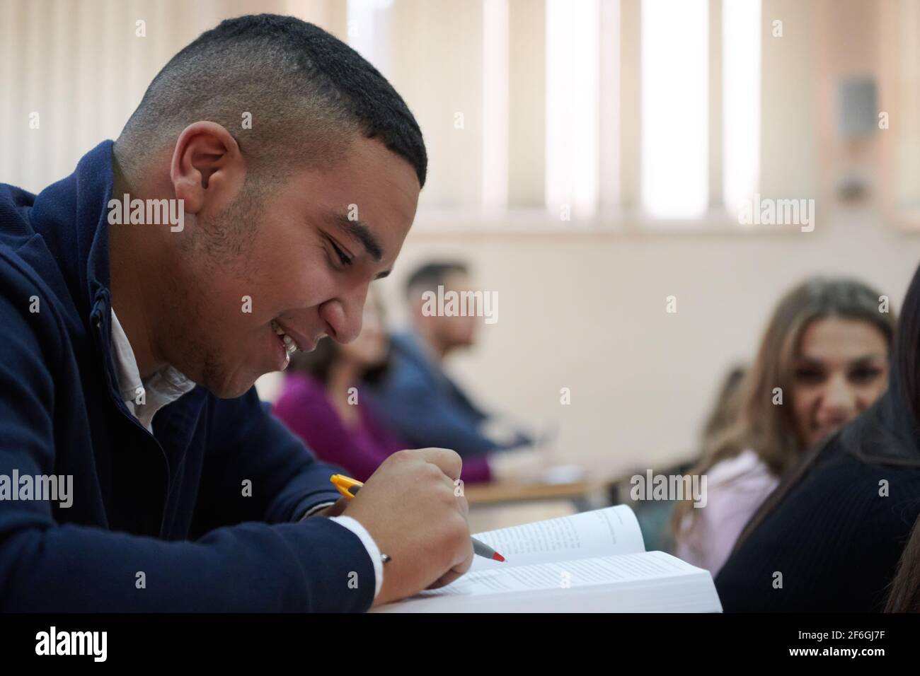 student taking notes while studying in high school. Satisfied young man ...